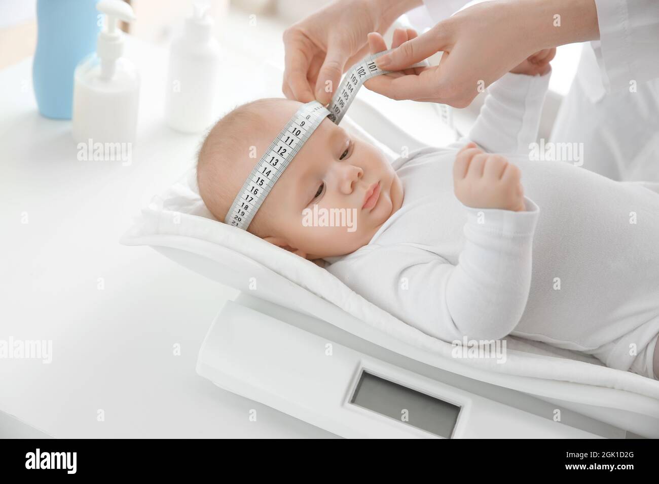 Doctor examining baby on scales in room Stock Photo - Alamy