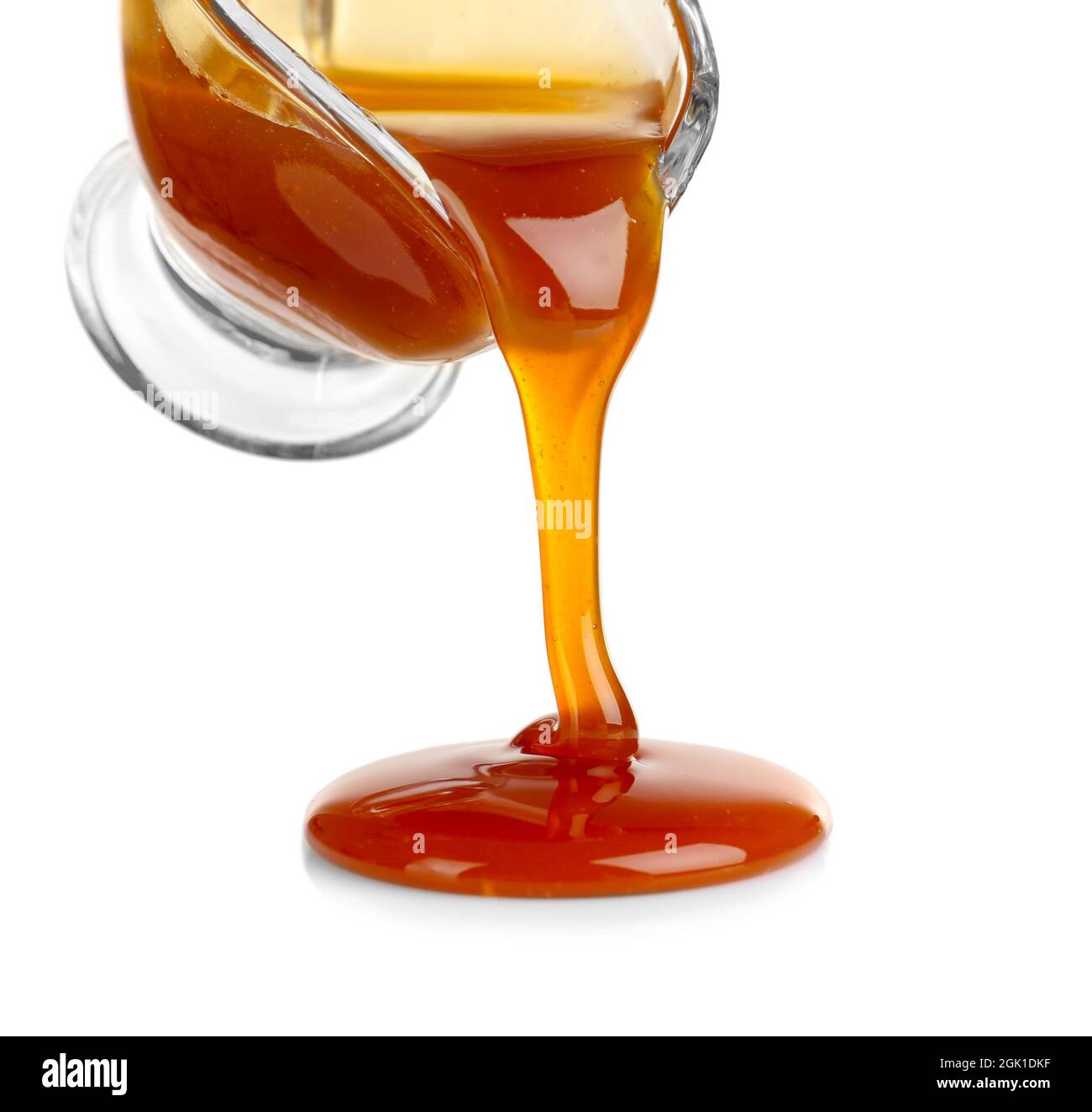 Pouring caramel sauce onto white background Stock Photo - Alamy