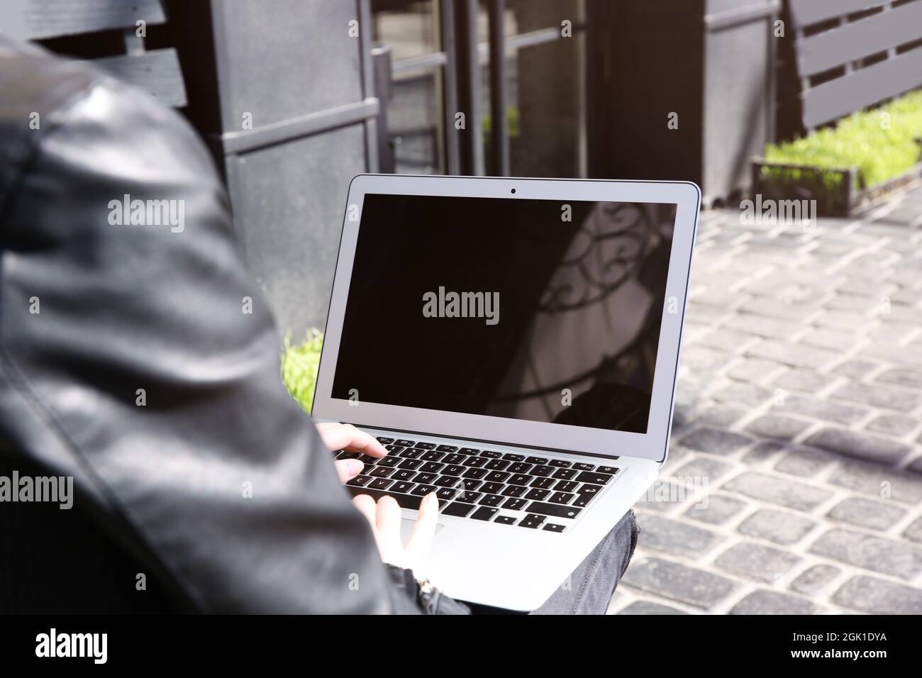 Young girl using laptop outdoors Stock Photo - Alamy