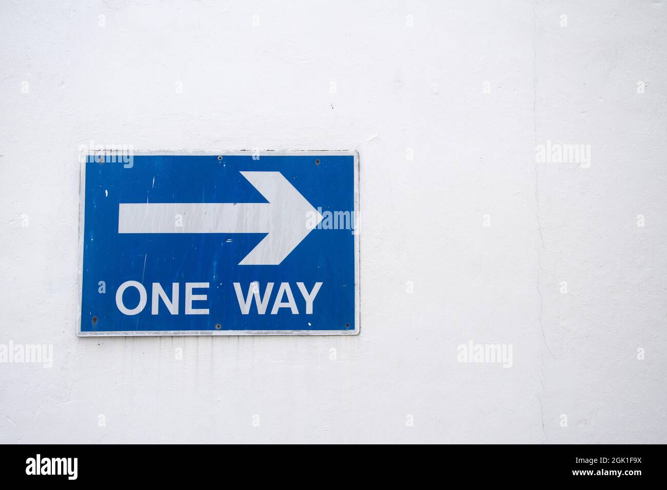 One way right arrow sign on the wall. White on blue background Stock ...
