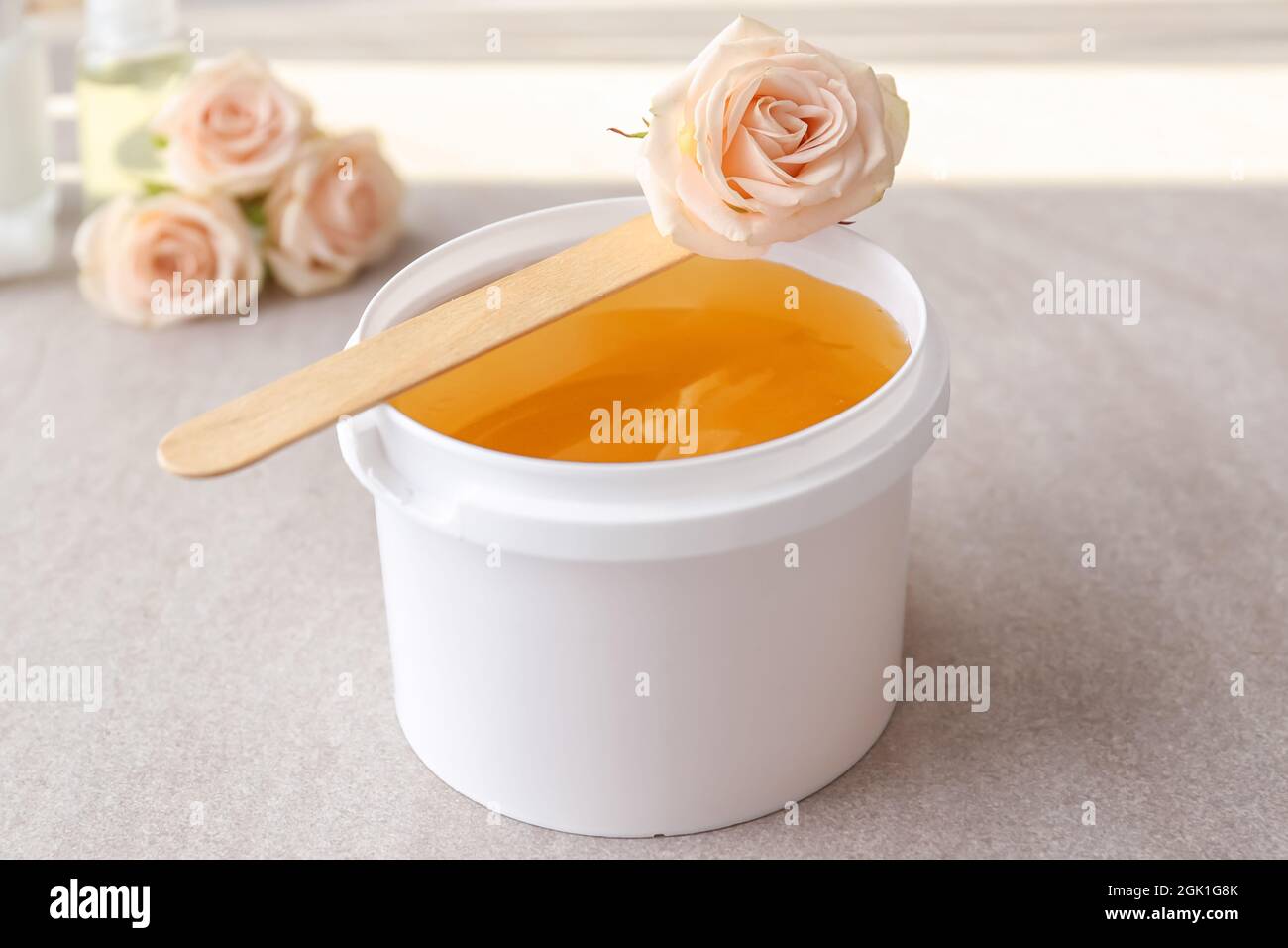 Plastic bucket with sugaring paste, wooden stick and flower on table ... Plastic bucket with sugaring paste, wooden stick and flower on table ...