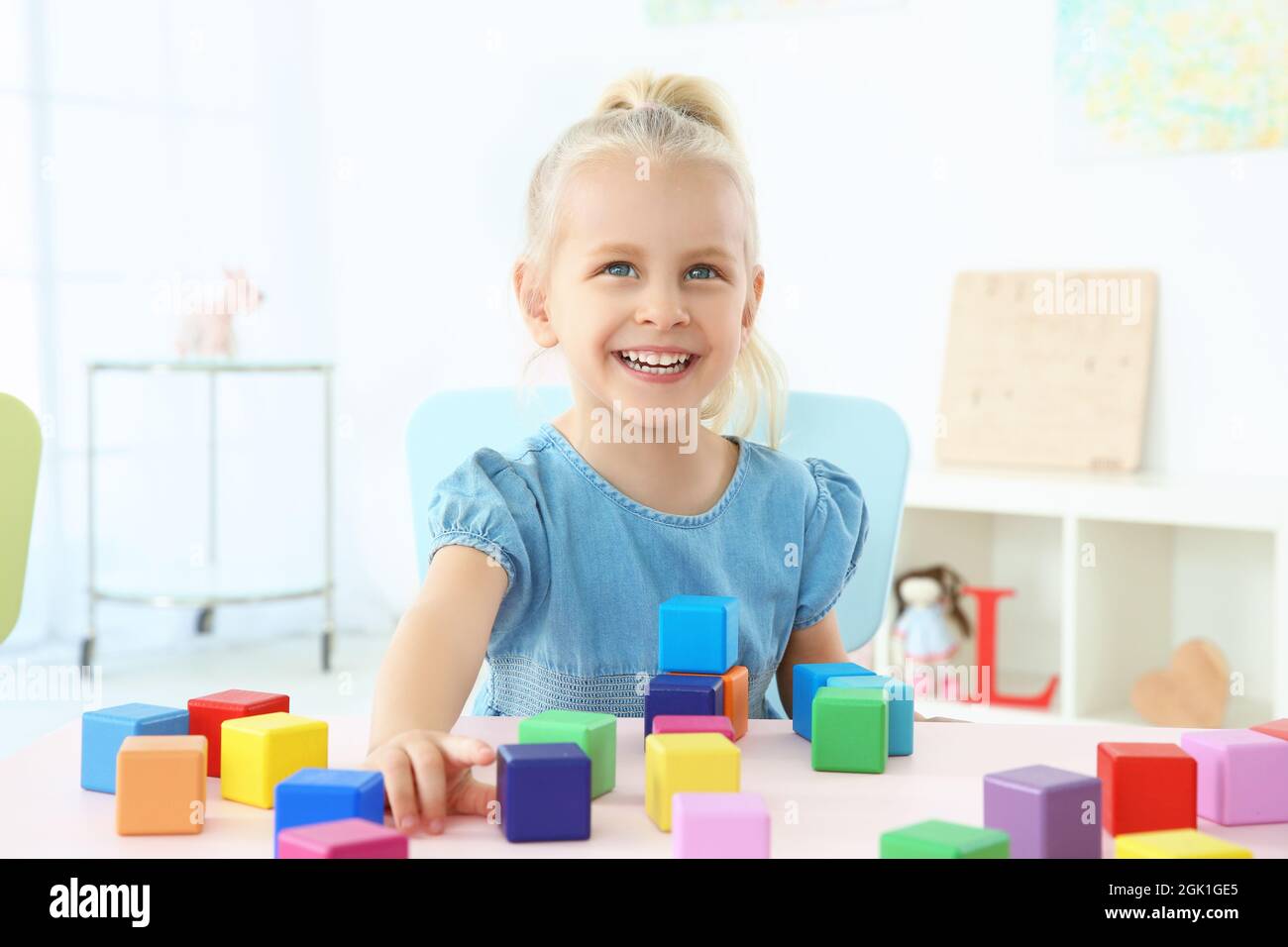Cute little girl playing with colorful cubes at home Stock Photo - Alamy