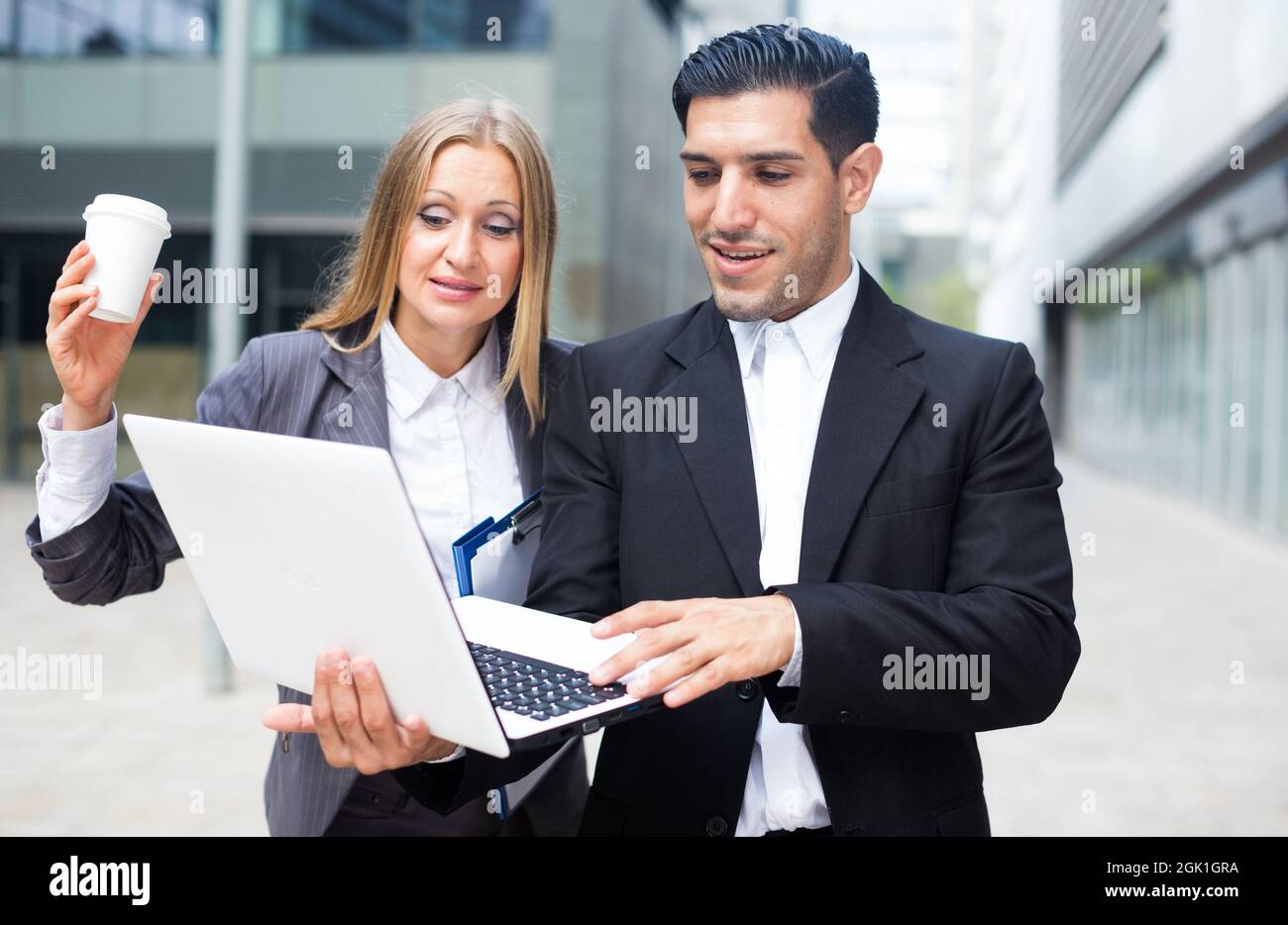 Two office workers are examining project on a laptop Stock Photo - Alamy
