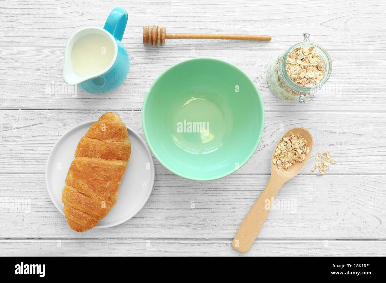 Composition with empty bowl, nutritious oatmeal and croissant for ...
