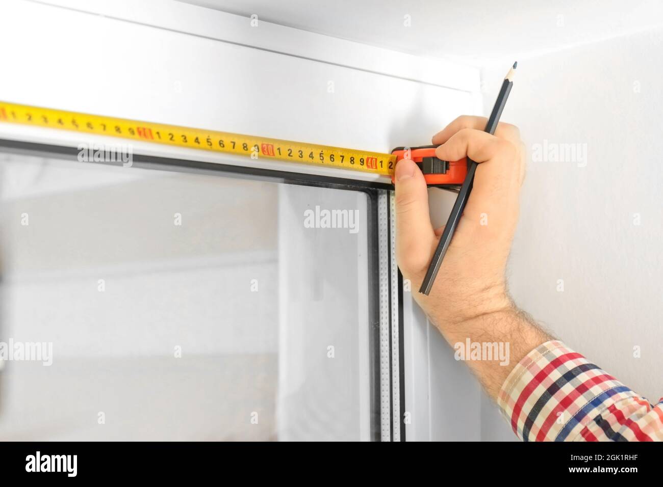 Man marking off window frame at home Stock Photo - Alamy