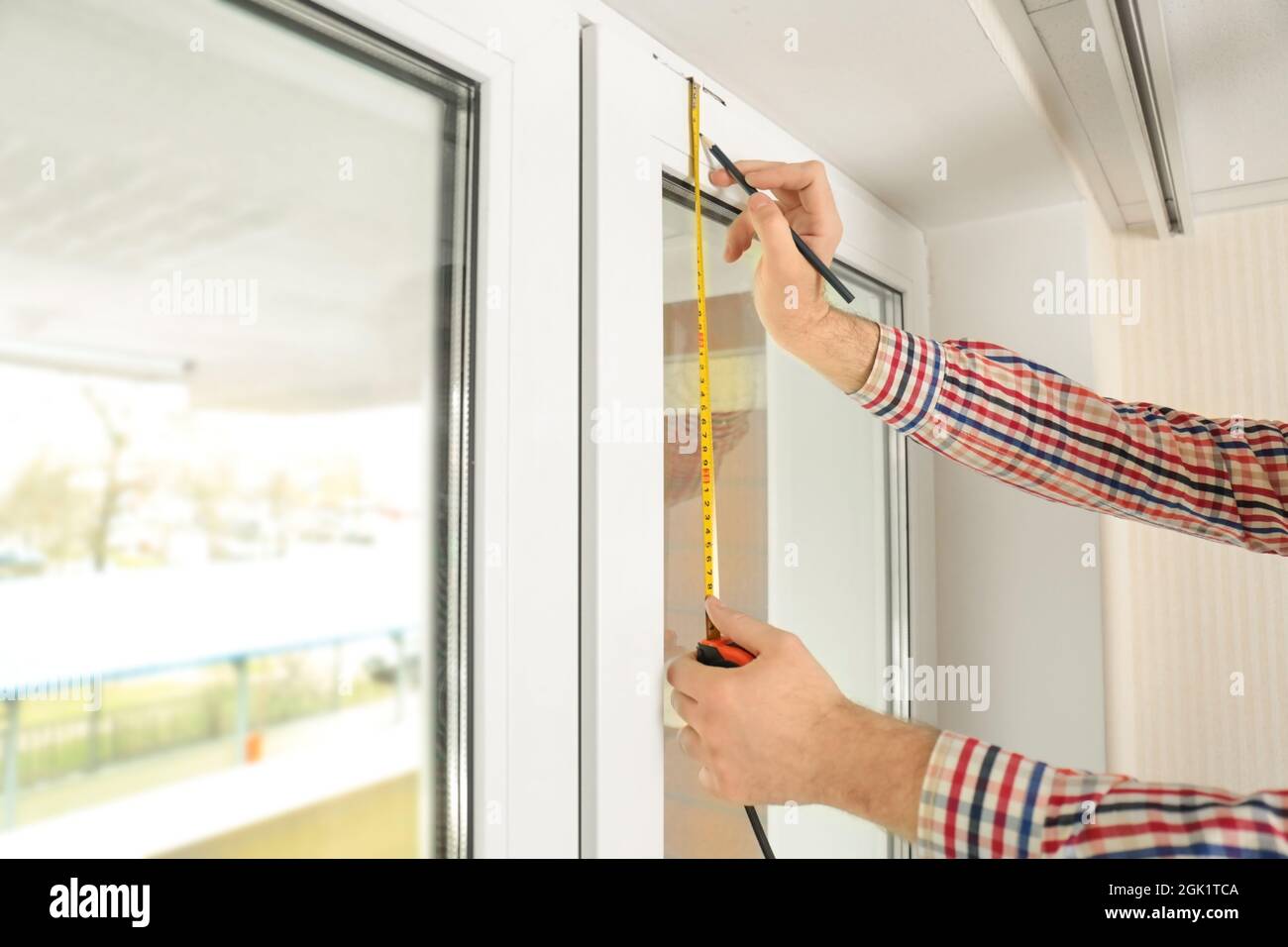 Man marking off window frame at home Stock Photo - Alamy