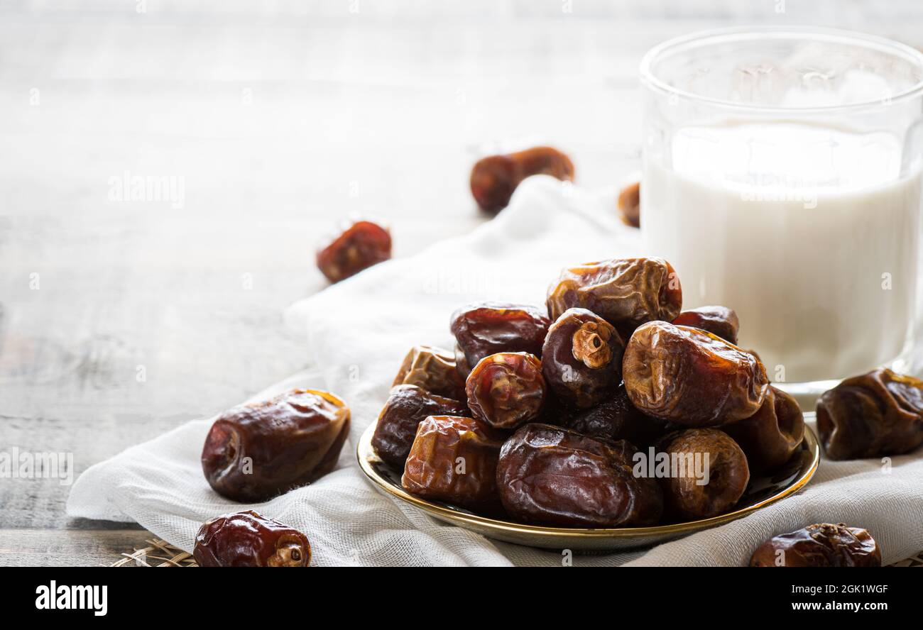Milk and dates fruit on dark wooden background. Muslim simple Iftar ...