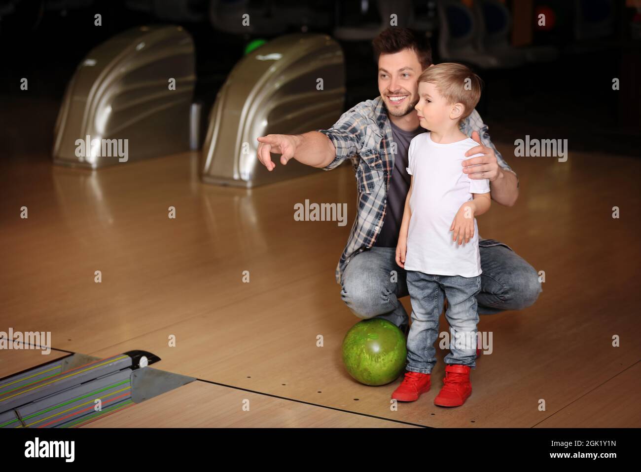Cute child with father in bowling club Stock Photo - Alamy