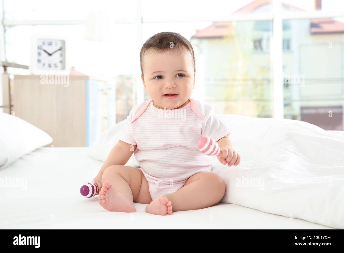 Cute little baby with rattles at home Stock Photo - Alamy
