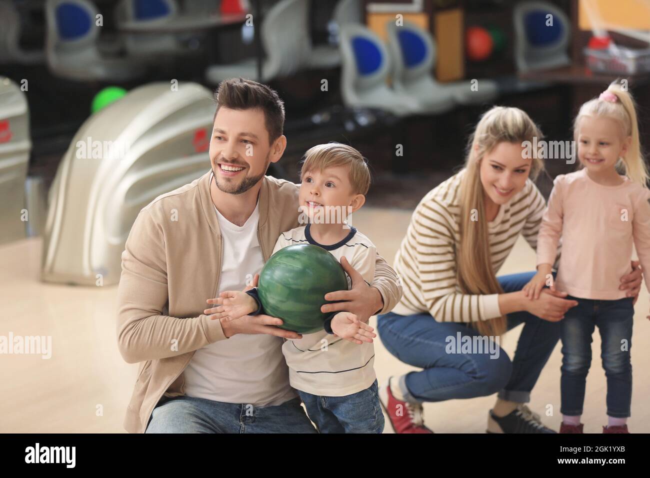 Family having fun at bowling club Stock Photo - Alamy