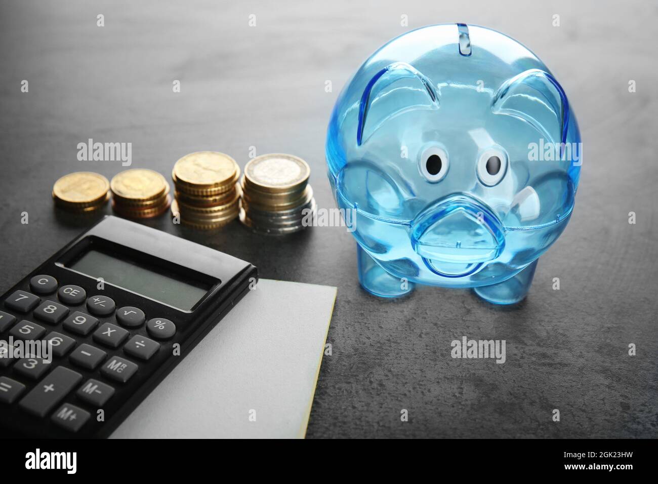 Composition of piggy bank, coins and calculator on grey table Stock ...