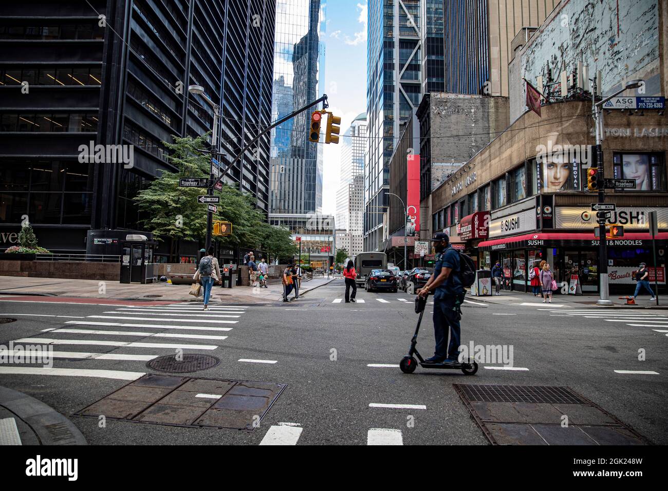 Pedestrians walk across Broadway at the intersection of Maiden Lane ...