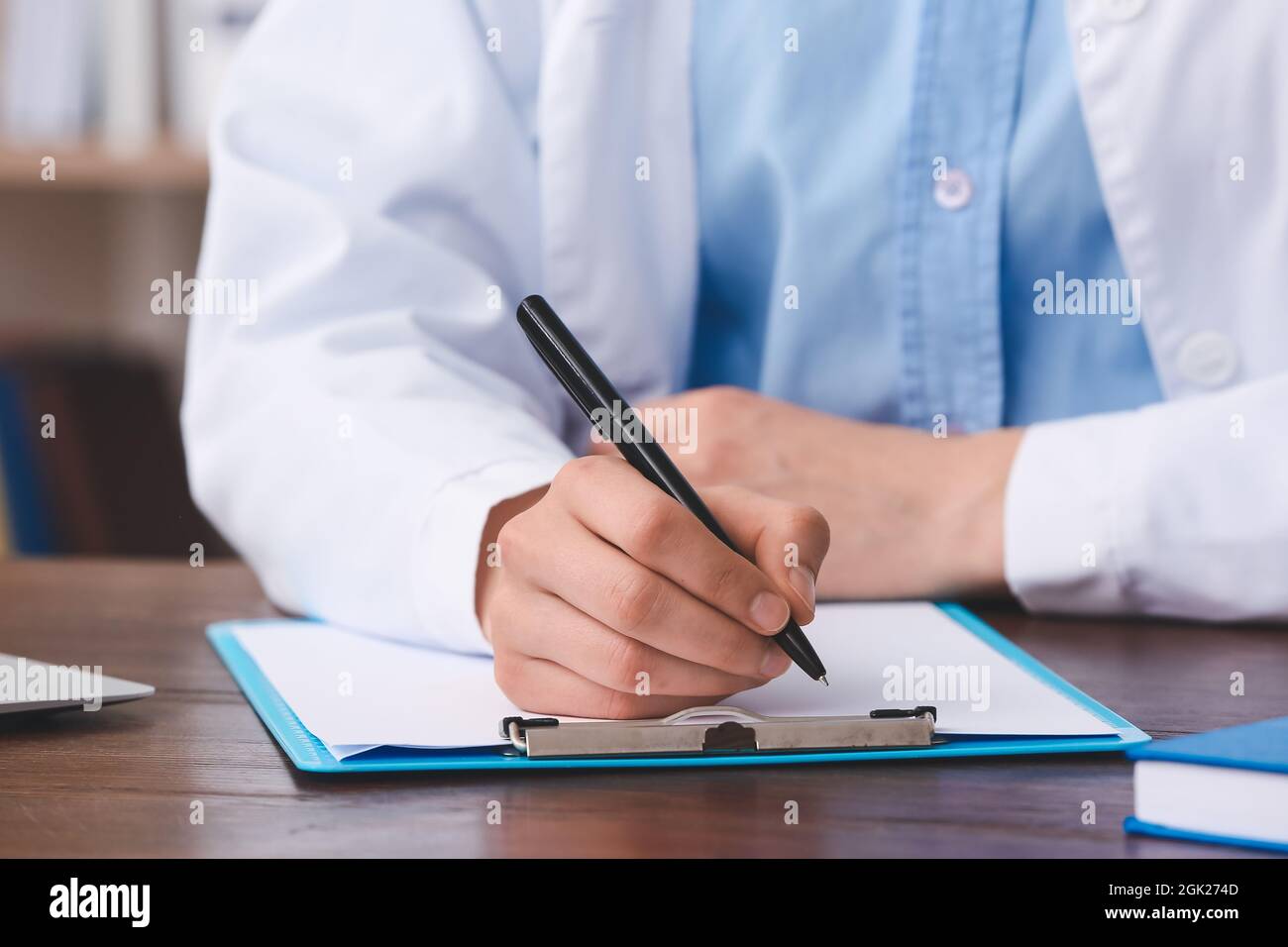Female doctor writing prescription in clinic Stock Photo - Alamy