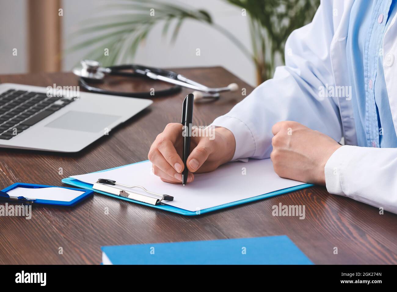 Female doctor writing prescription in clinic Stock Photo - Alamy