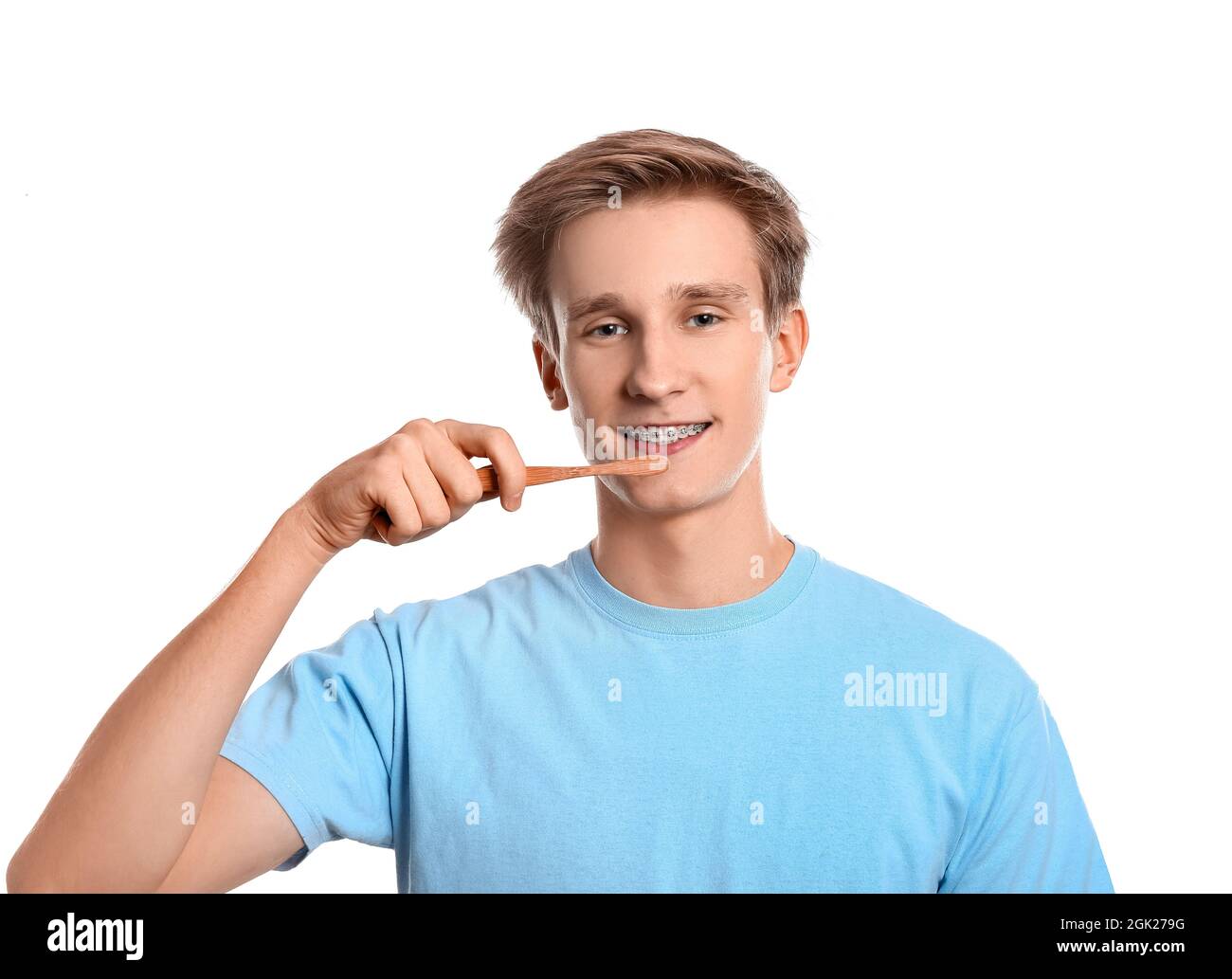 Handsome man with dental braces and toothbrush on white background ...