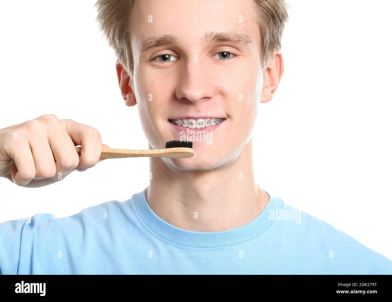 Handsome man with dental braces and toothbrush on white background ...