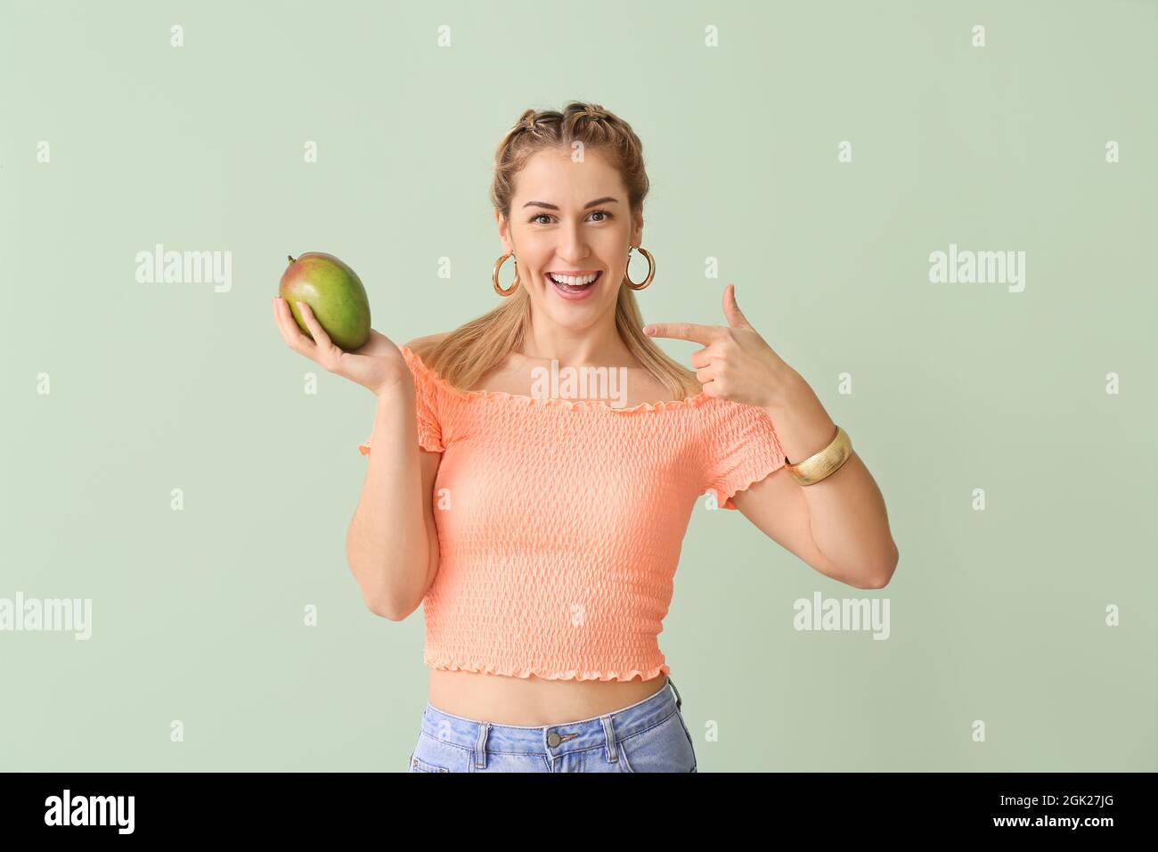 Beautiful woman with fresh mango on green background Stock Photo - Alamy