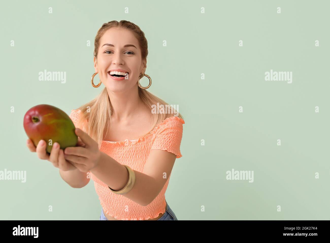 Beautiful woman with fresh mango on green background Stock Photo - Alamy