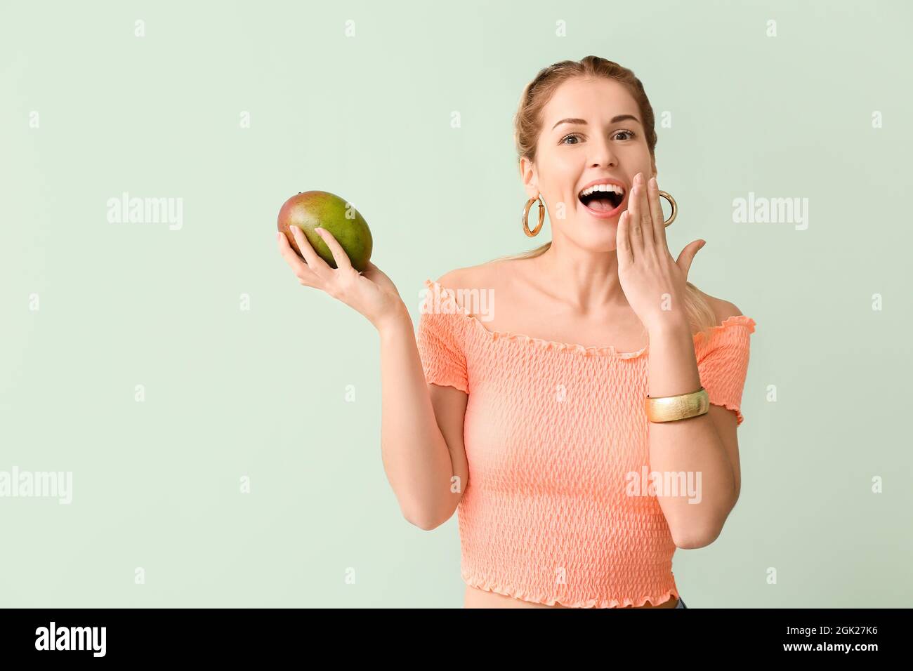 Beautiful woman with fresh mango on green background Stock Photo - Alamy