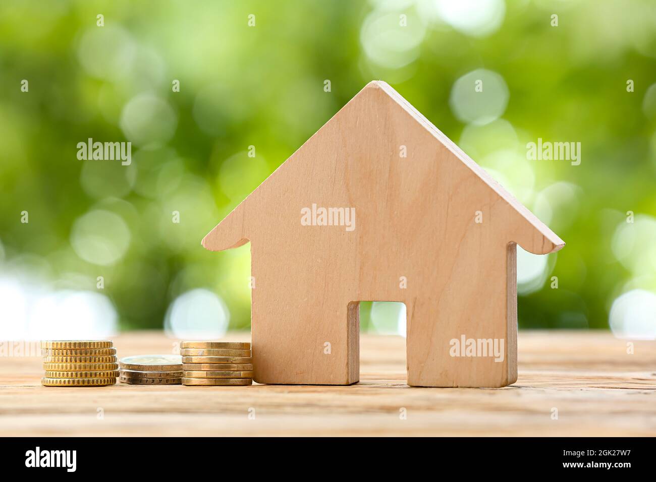 Figure of house with coins outdoors Stock Photo - Alamy