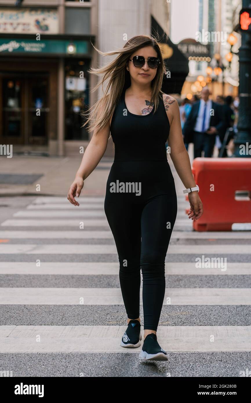 Outdoor fashion portrait of a stunning woman walking through the city ...