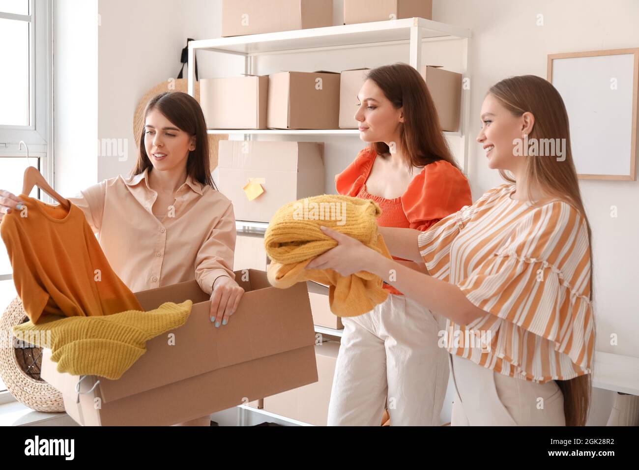 Female sellers with clothes in warehouse store Stock Photo - Alamy