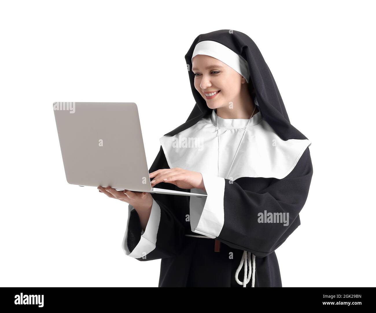 Young nun with laptop on white background Stock Photo - Alamy