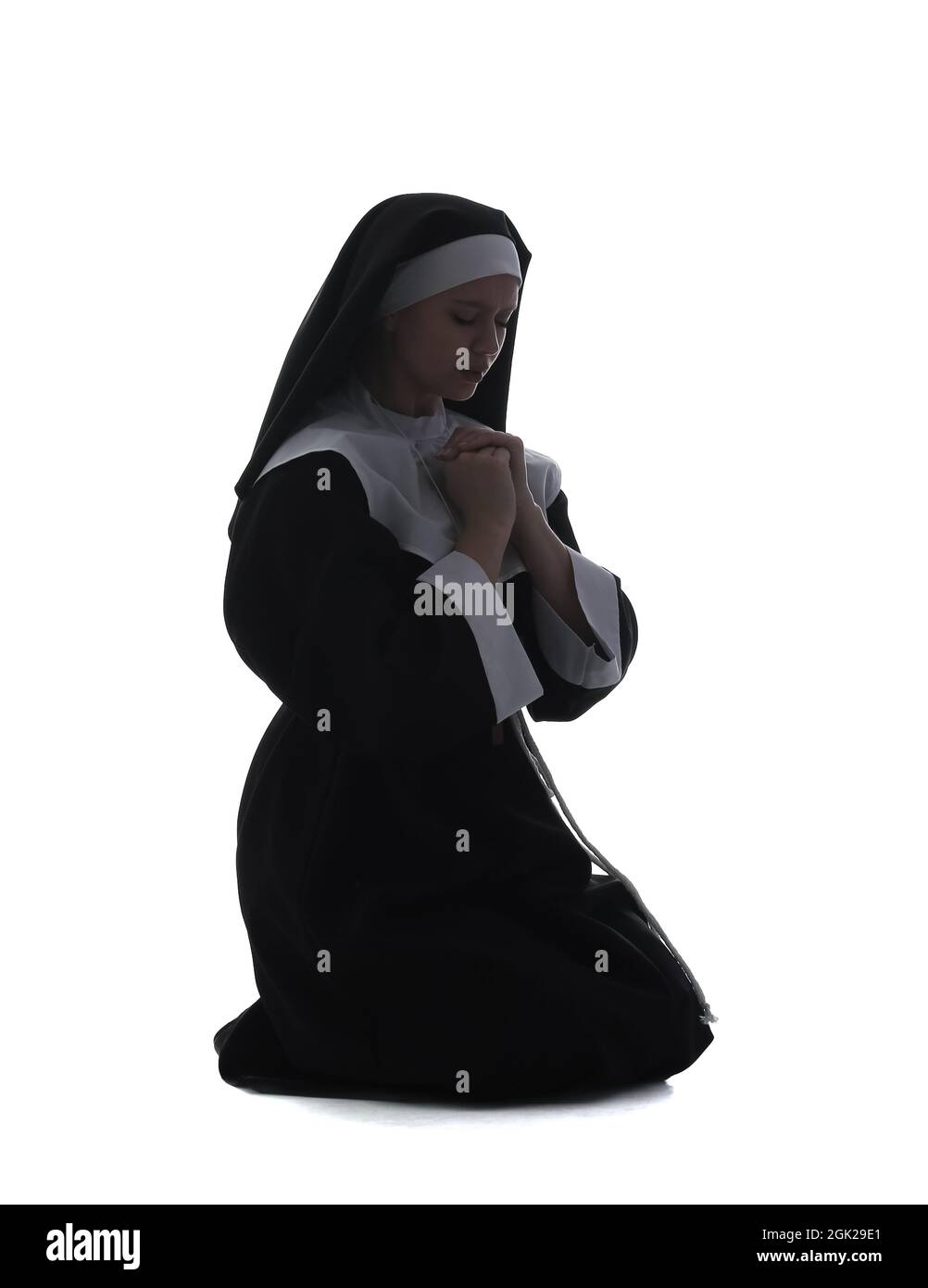 Silhouette of young praying nun on white background Stock Photo - Alamy