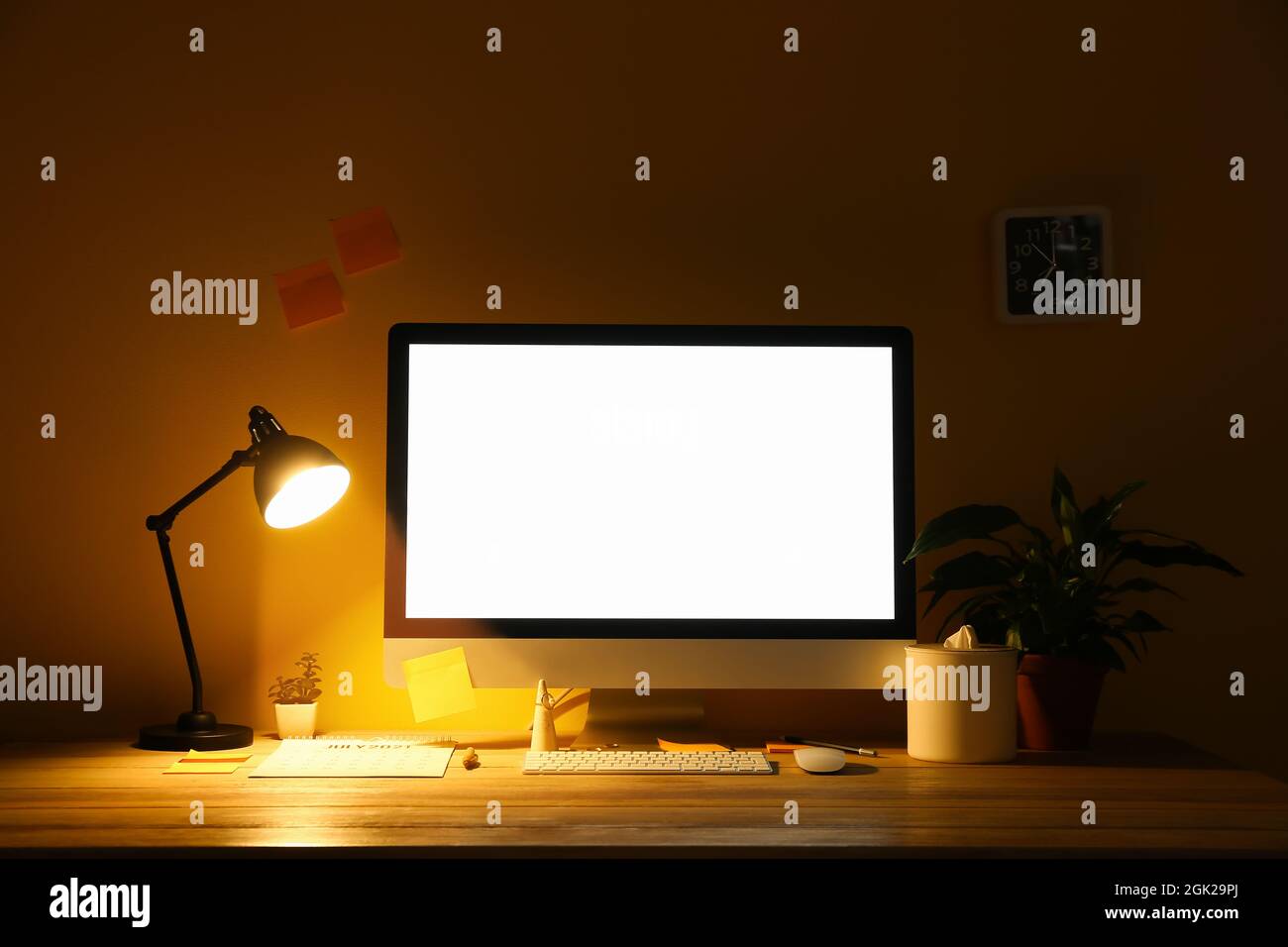 Workplace with modern computer and glowing lamp in dark room Stock ...
