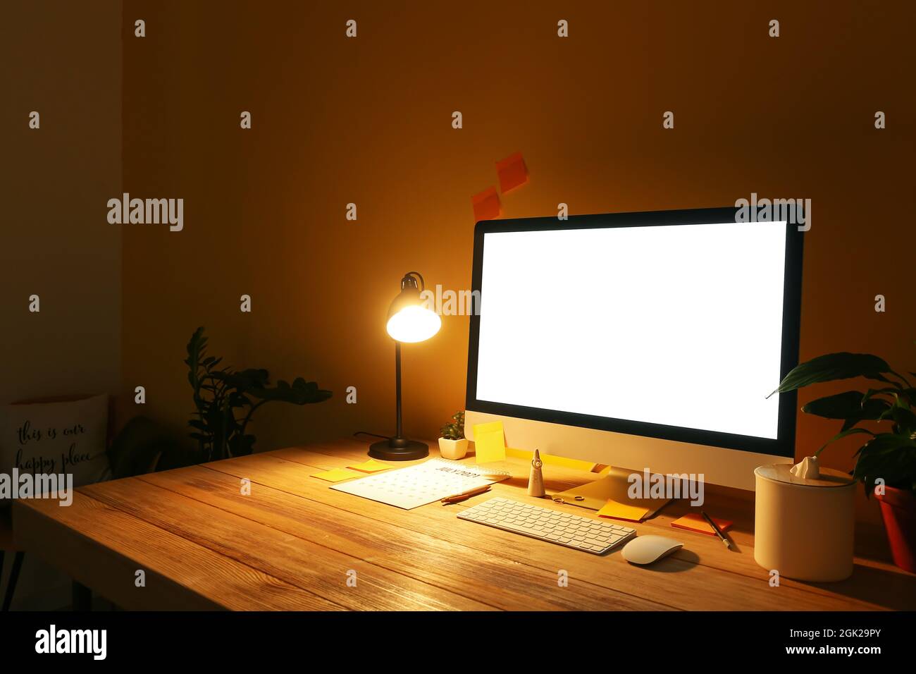 Workplace with modern computer and glowing lamp in dark room Stock ...