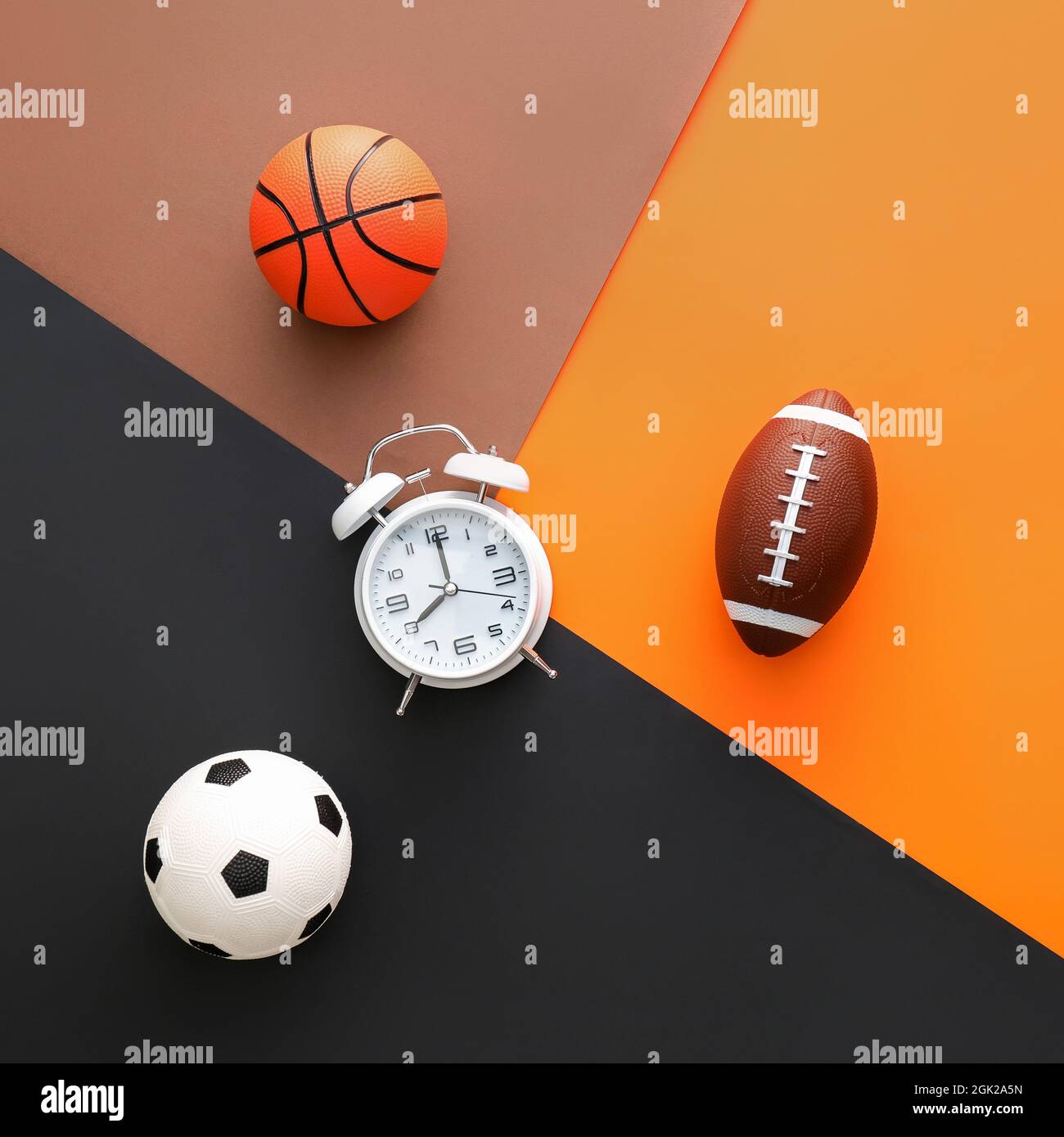 Alarm clock with balls on color background Stock Photo - Alamy