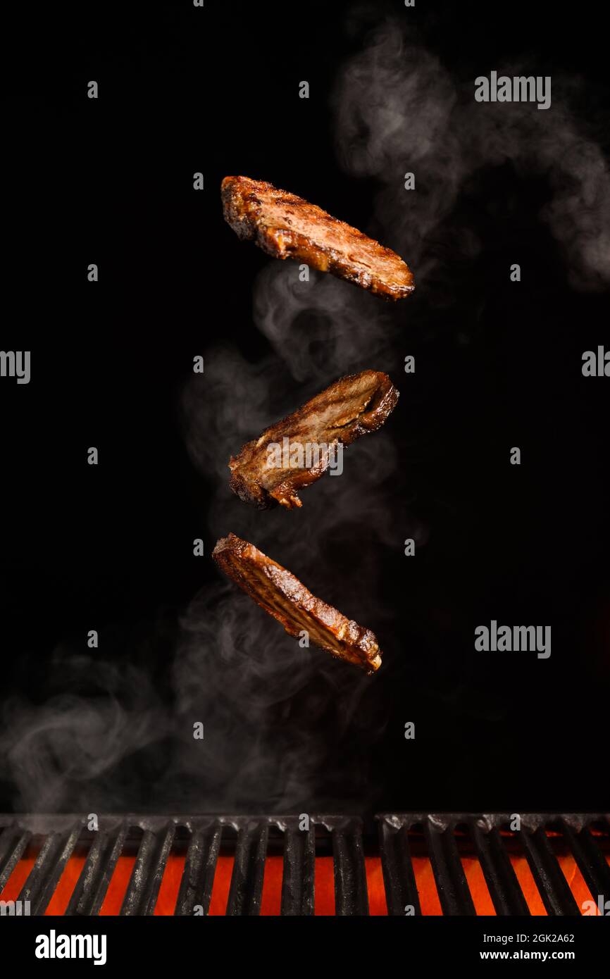 Flying beef brisket in smoke over grill on dark background Stock Photo ...