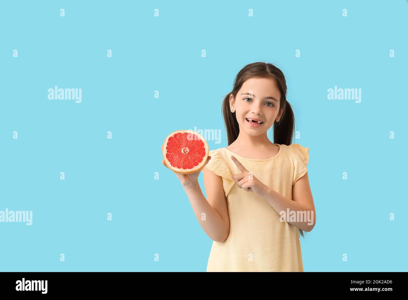 Little girl with fresh tasty grapefruit on color background Stock Photo ...