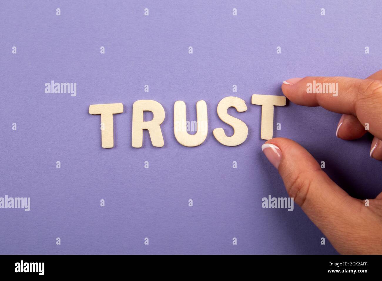 TRUST. Letters with text on a purple background Stock Photo - Alamy