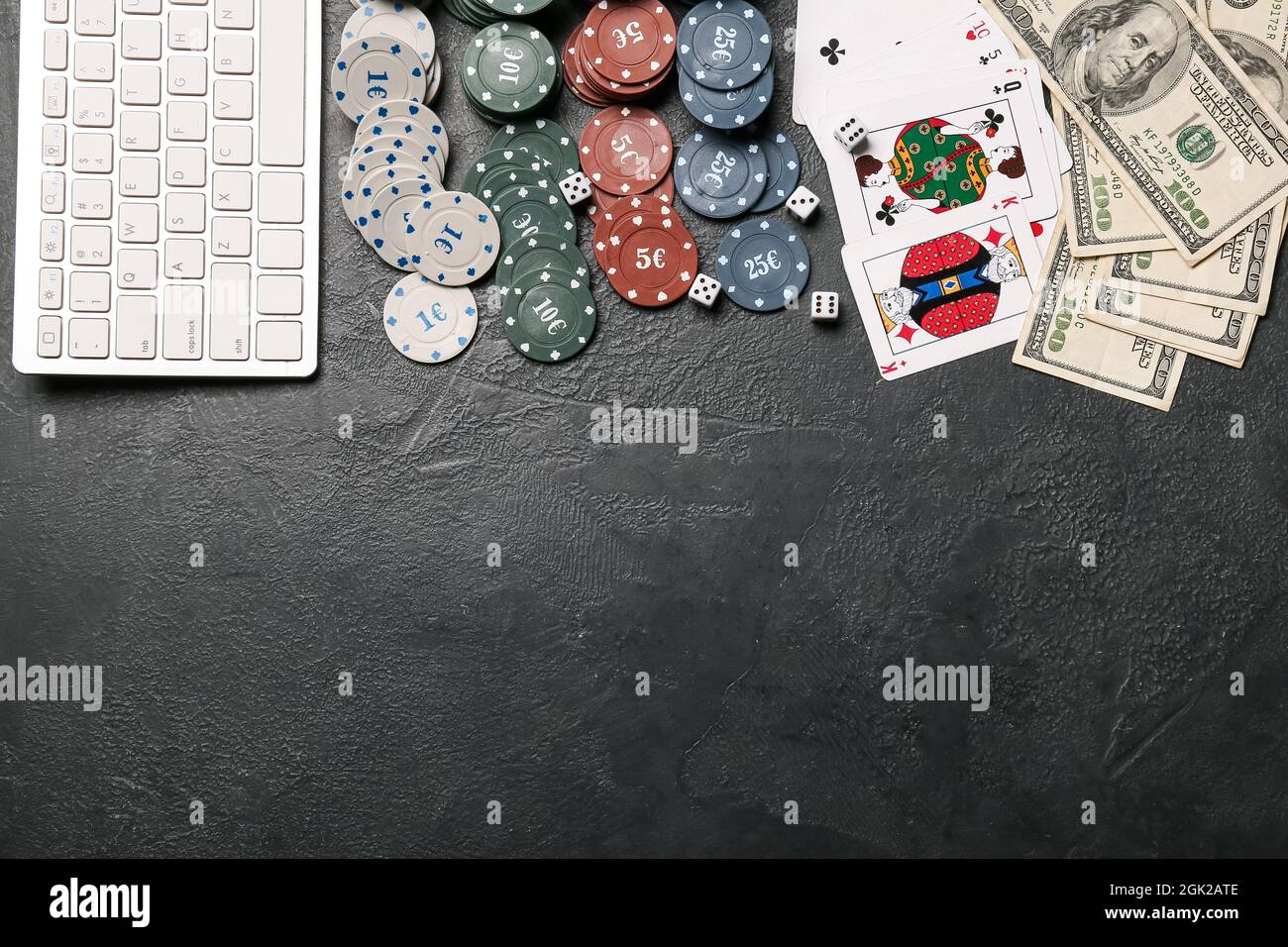 Dollar banknotes, poker chips, playing cards and computer keyboard on ...