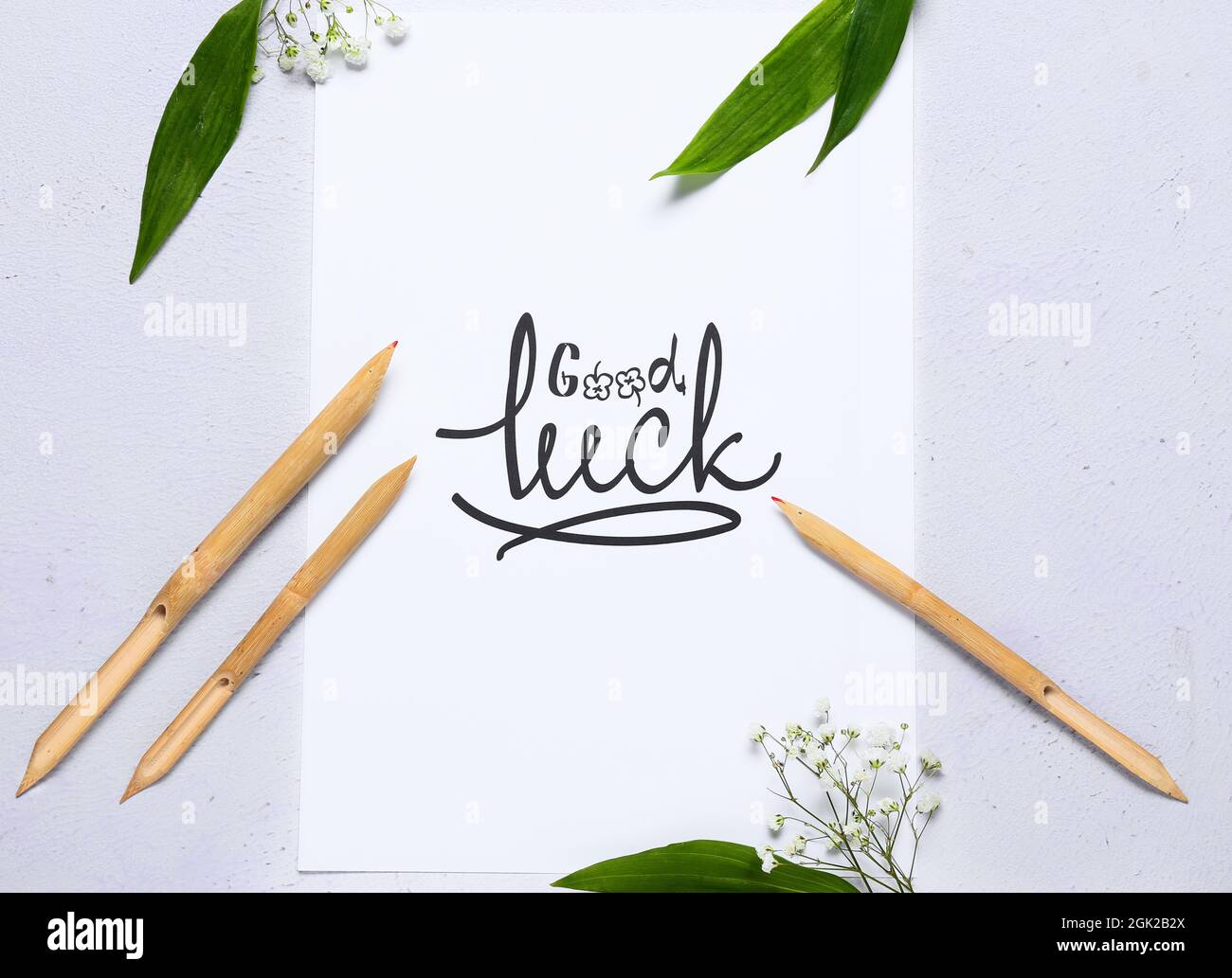 Paper with text GOOD LUCK, dip pens and flowers on white background ...