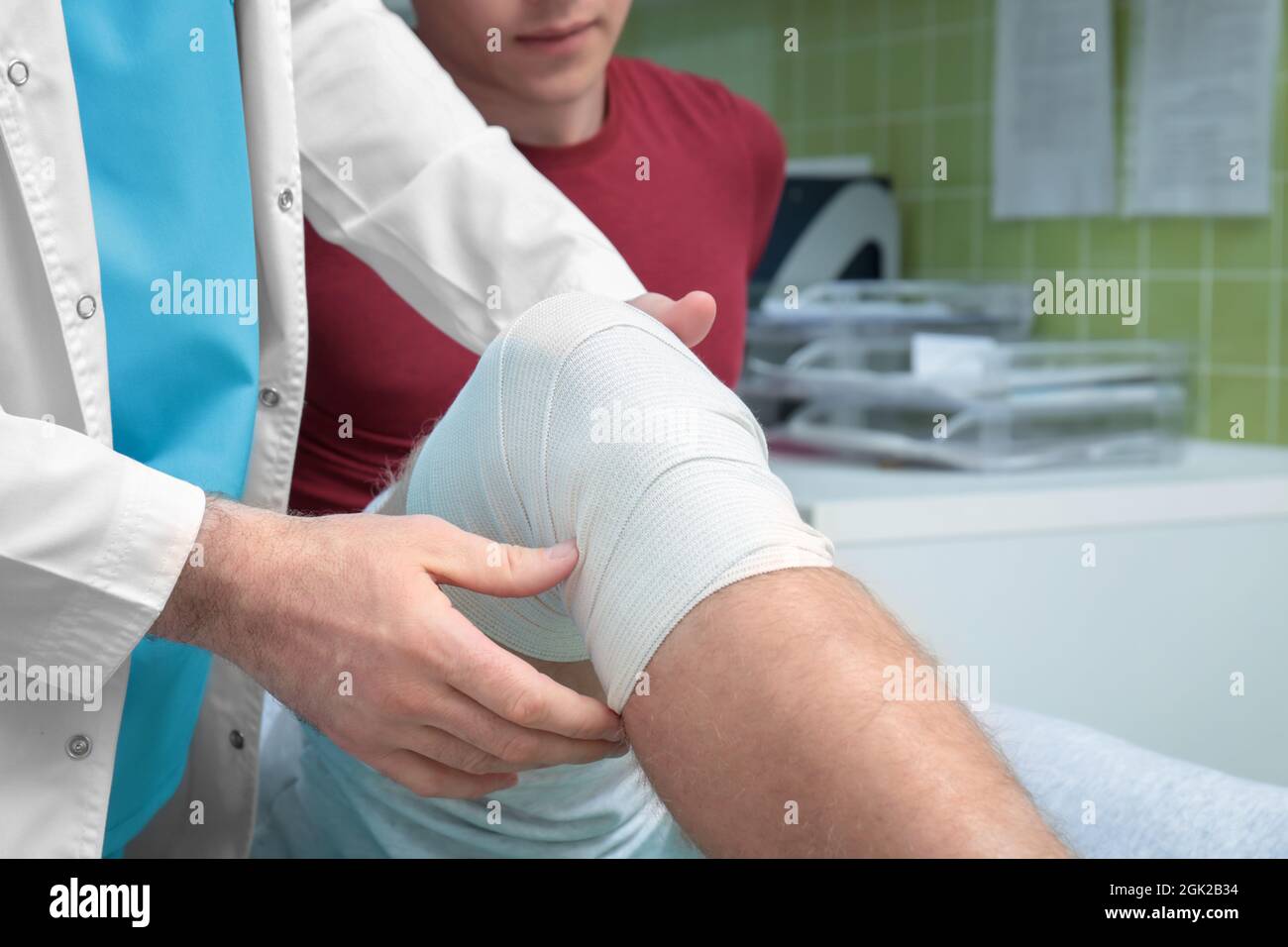 Orthopedist applying bandage onto patient's leg in clinic Stock Photo ...
