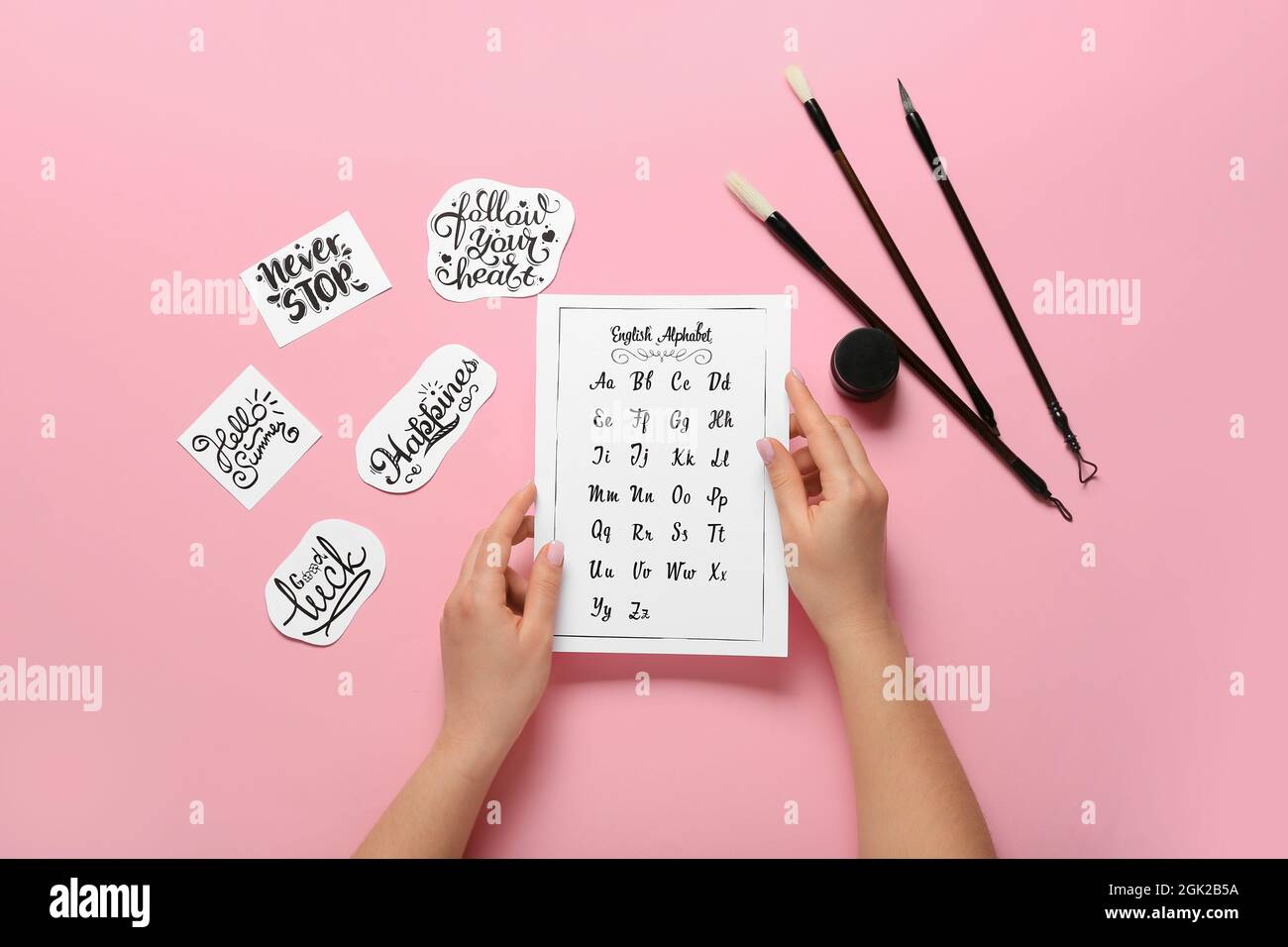 Woman with English alphabet and brushes on pink background Stock Photo ...