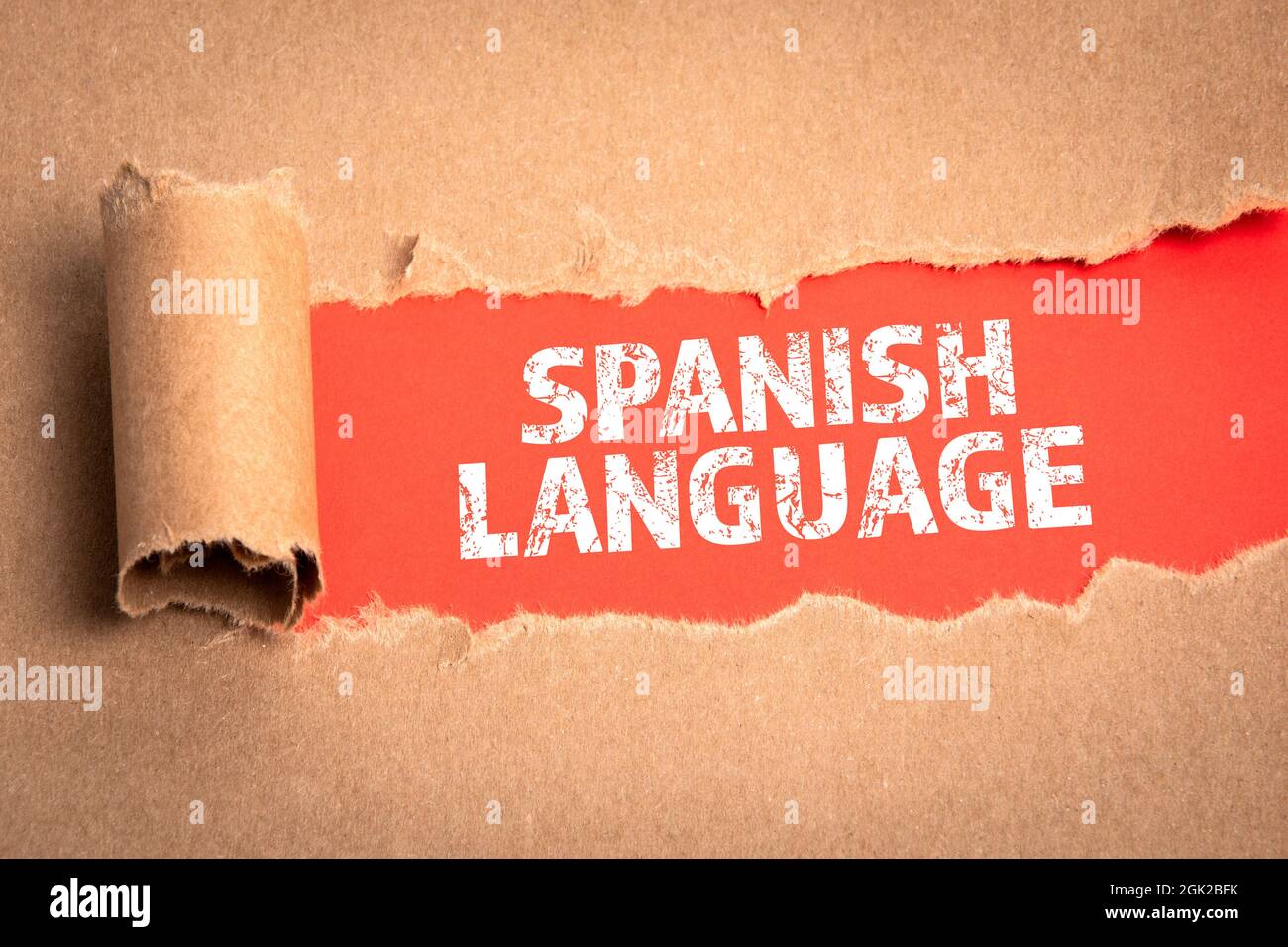 Spanish Language. Torn cardboard on a red background Stock Photo - Alamy