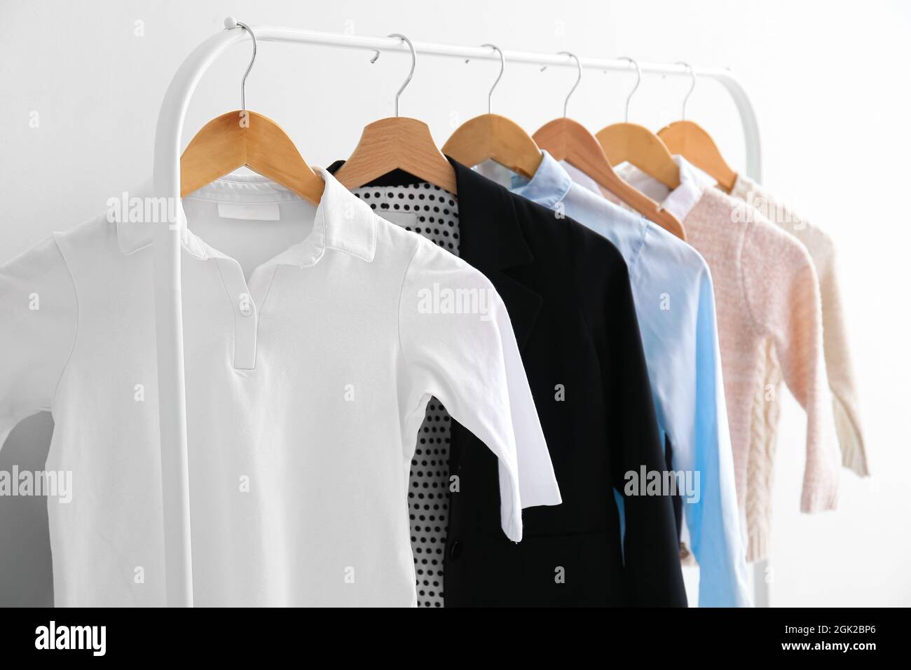 Rack with school uniform on light background Stock Photo - Alamy