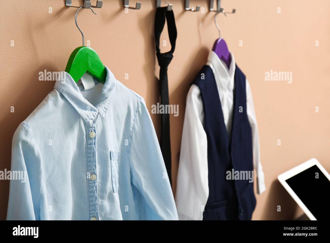 School uniform hanging on color wall Stock Photo - Alamy