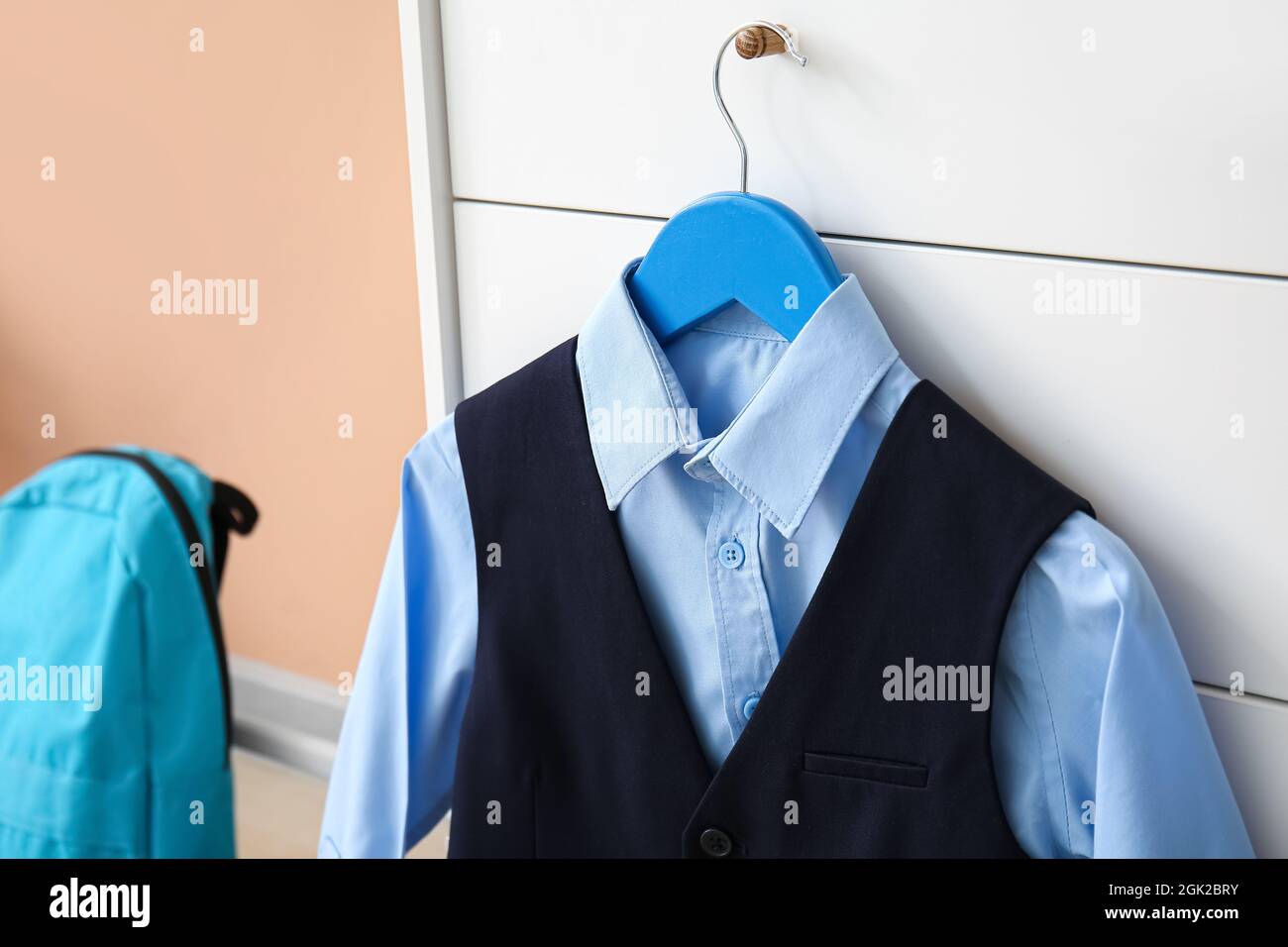 School uniform hanging on chest of drawers in room, closeup Stock Photo ...