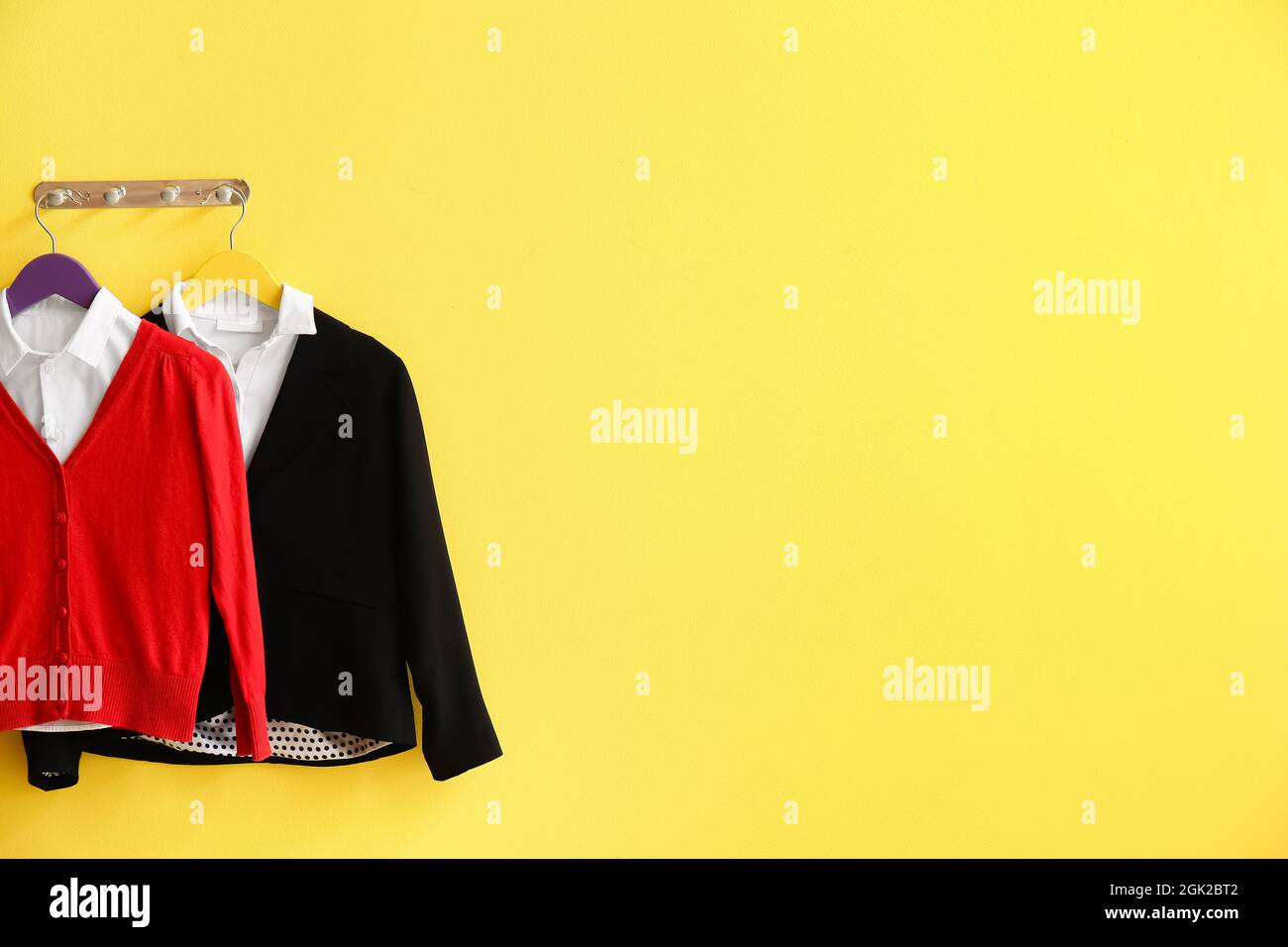 Hanger with stylish school uniform on color wall in room Stock Photo ...