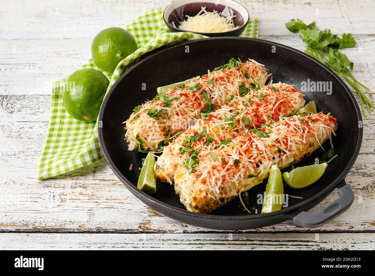 Frying pan with tasty Elote Mexican Street Corn on white wooden ...