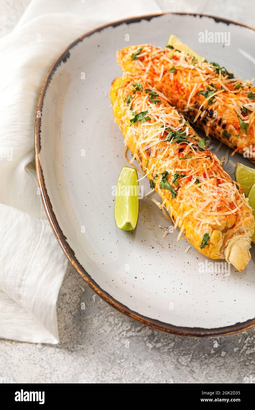 Plate with tasty Elote Mexican Street Corn on grey background, closeup ...