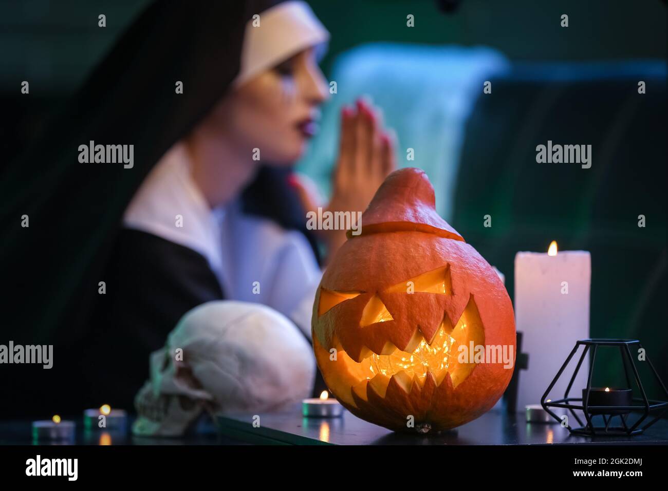 Halloween pumpkin and candles on table of praying nun Stock Photo - Alamy