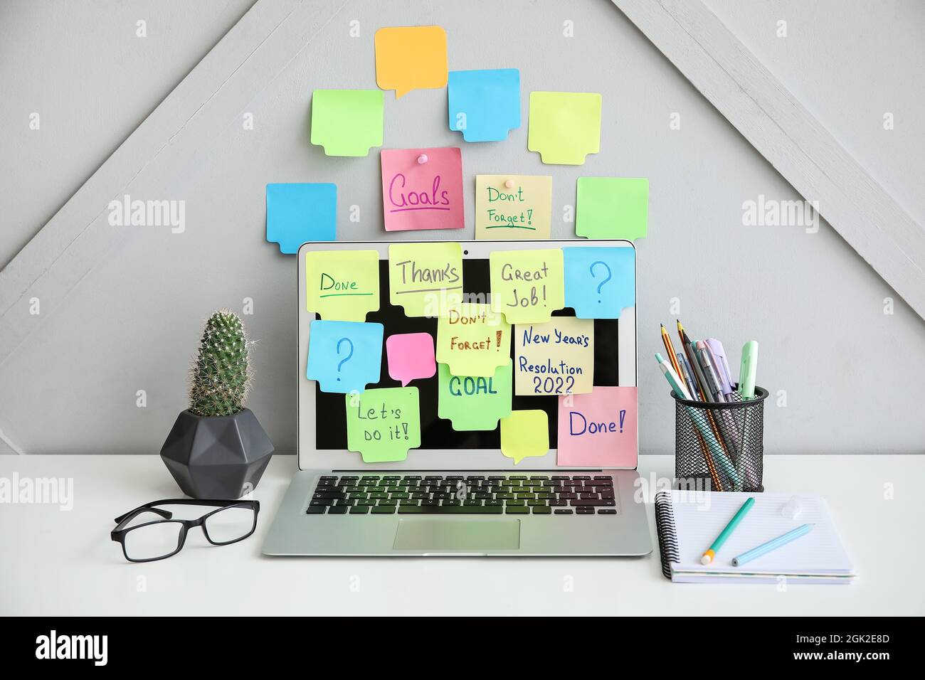 Modern workplace with laptop and sticky notes near light wall Stock ...