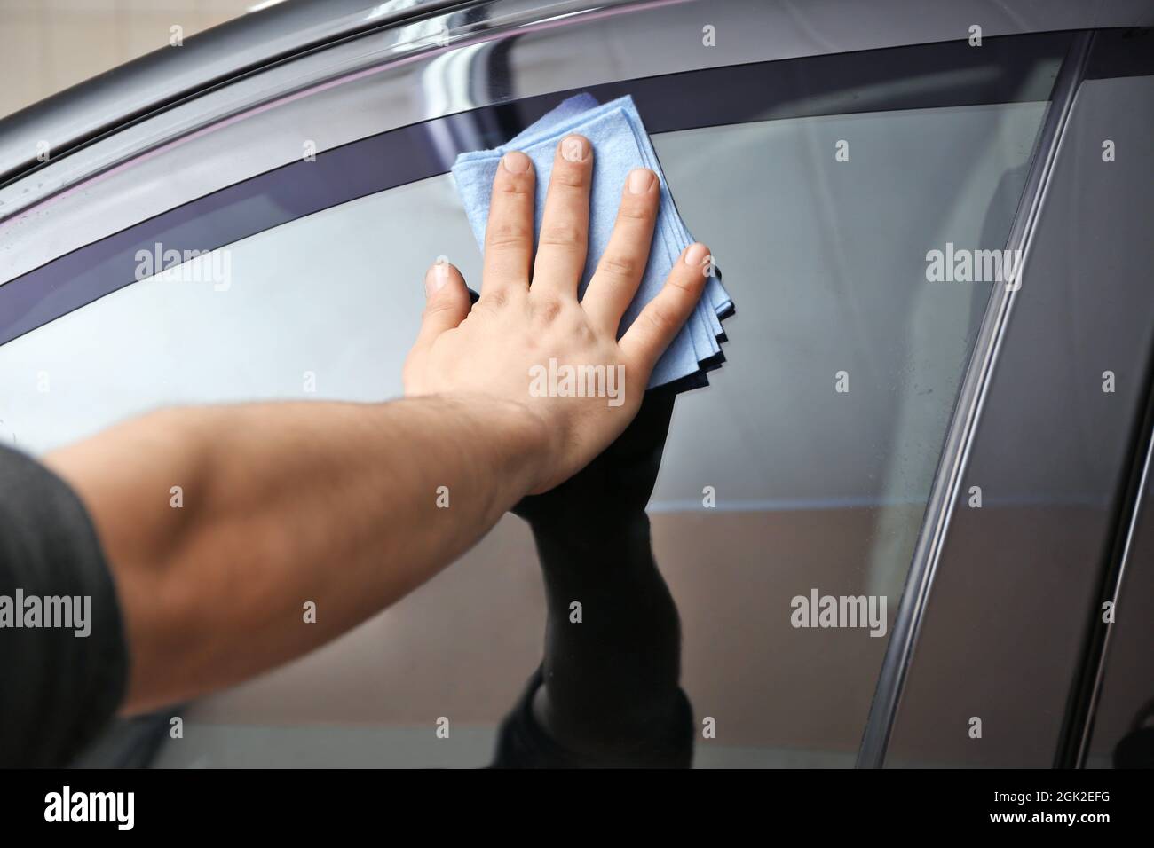 Worker polishing tinted car window Stock Photo - Alamy
