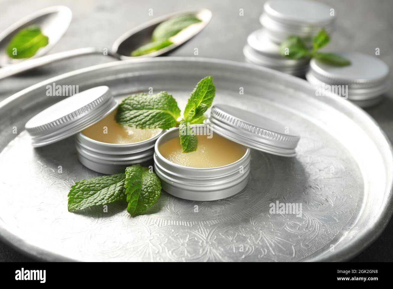 Containers with lemon balm salve and leaves on metal tray Stock Photo ...