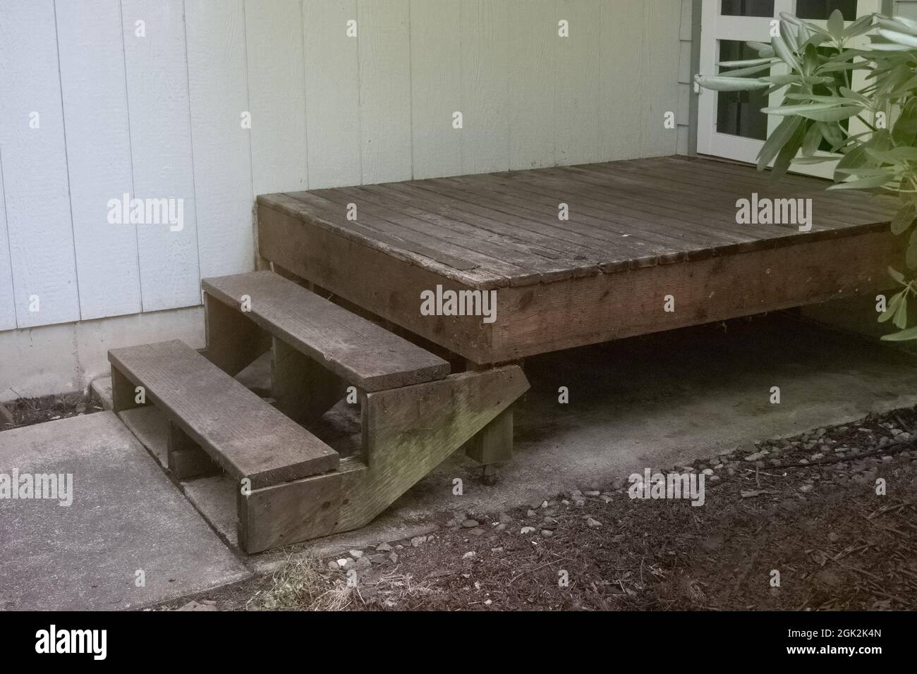 Old weathered front door landing with cedar plank steps discolored with ...